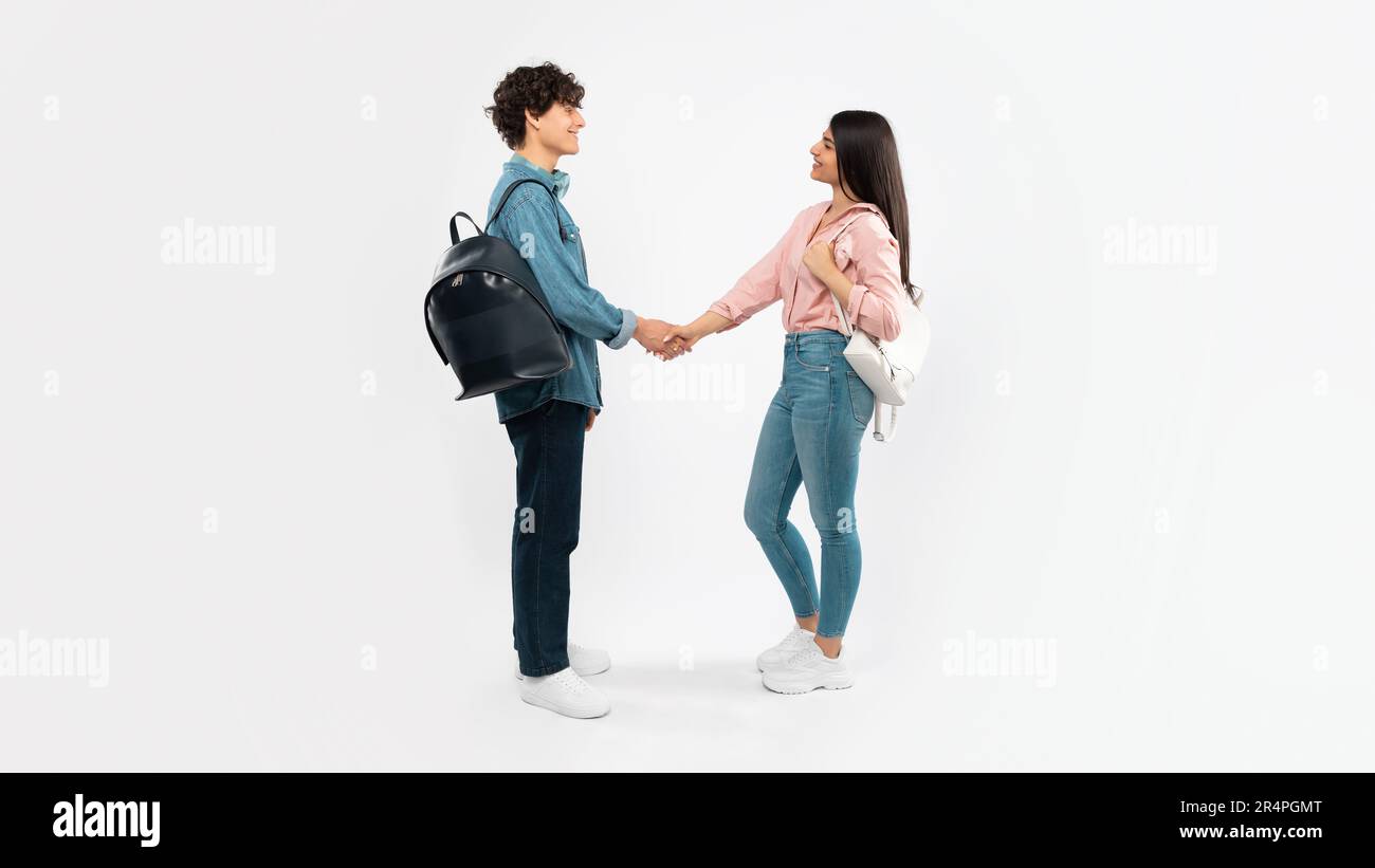 Happy Students Couple Shaking Hands Standing Over White Studio ...