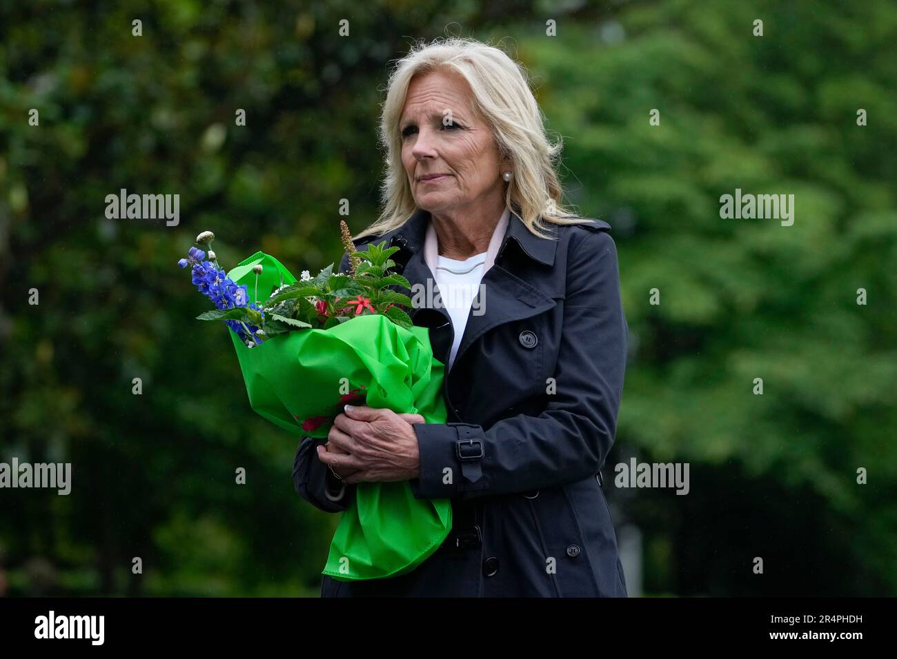First lady Jill Biden holds flowers as she waits while President Joe ...