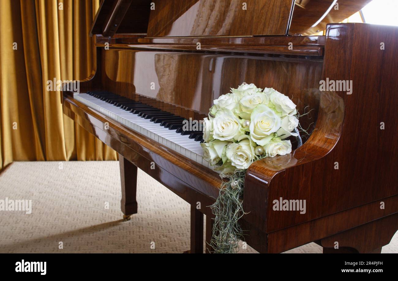 Wedding bouquet of white roses lying on the piano keys. Party decor ...