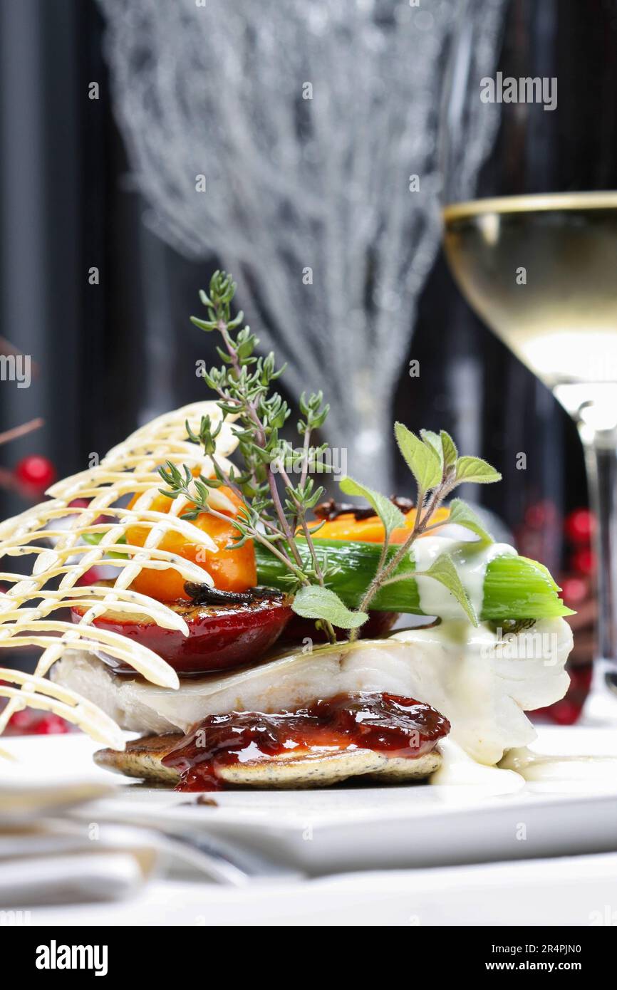A modern dish with zander and vegetables. Table setting in luxurious ...