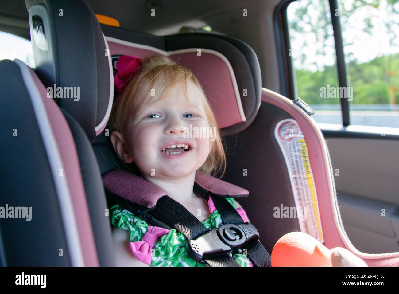 Two-year-old smiling girl in carseat on a road trip Stock Photo - Alamy
