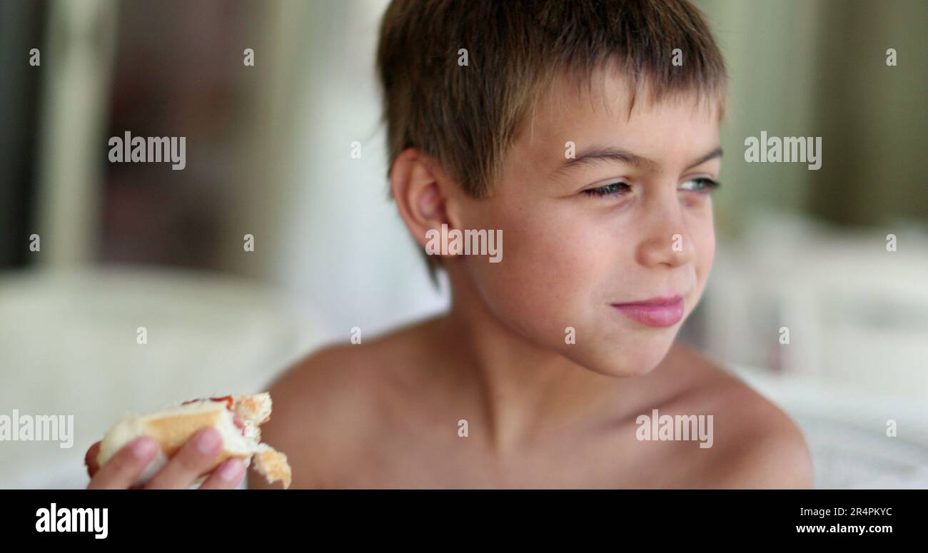 Happy child eating hot-dog. Handsome kid eats junk food Stock Photo - Alamy