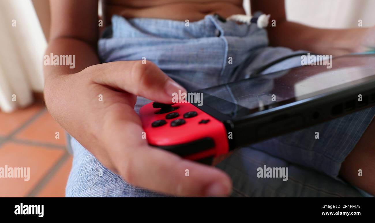 Kid playing game online holding controller Stock Photo - Alamy