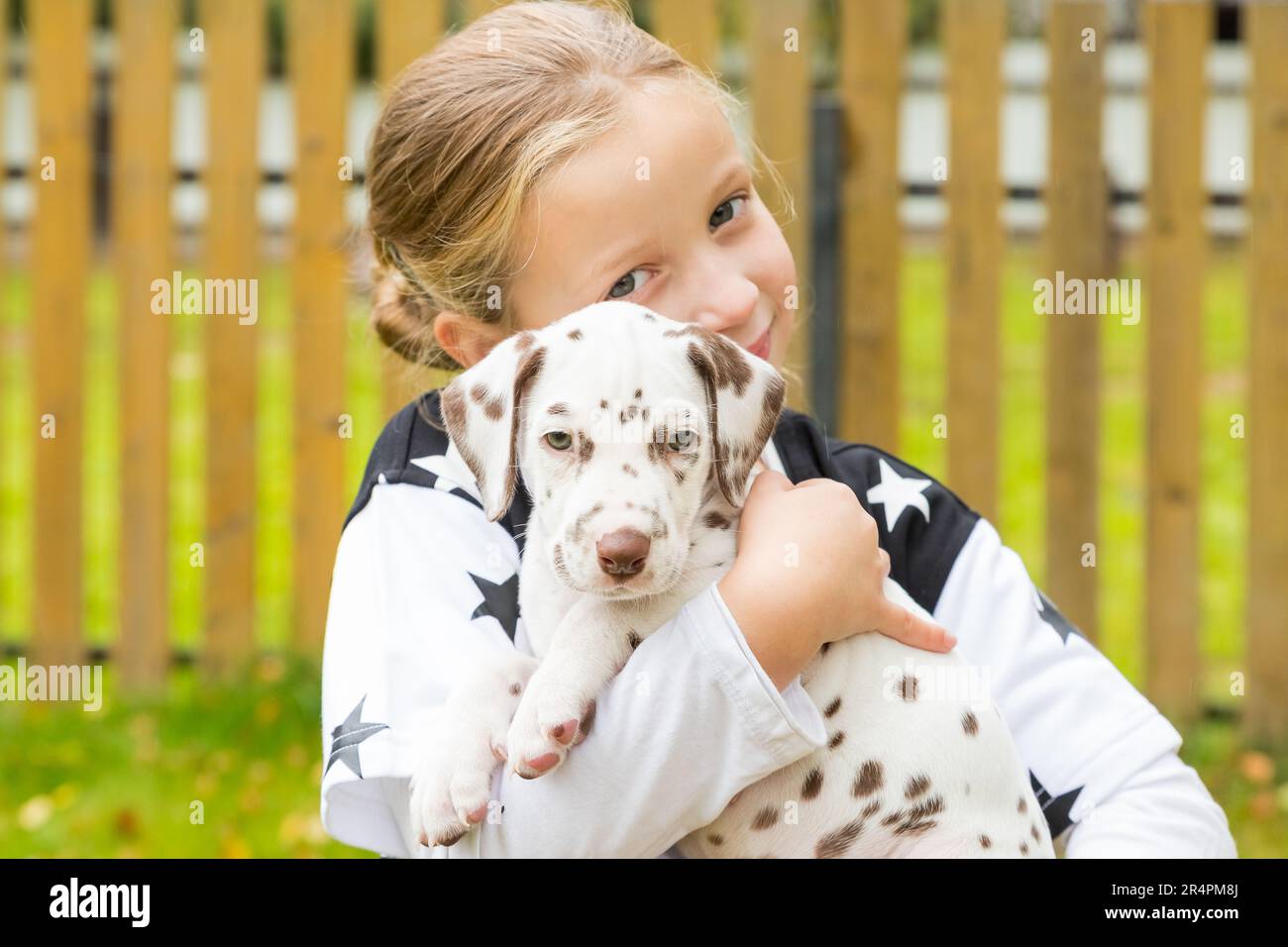 Kids play with cute little puppy of dalmatian. Children and baby dogs ...