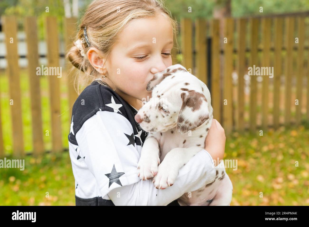 Kids play with cute little puppy of dalmatian. Children and baby dogs ...