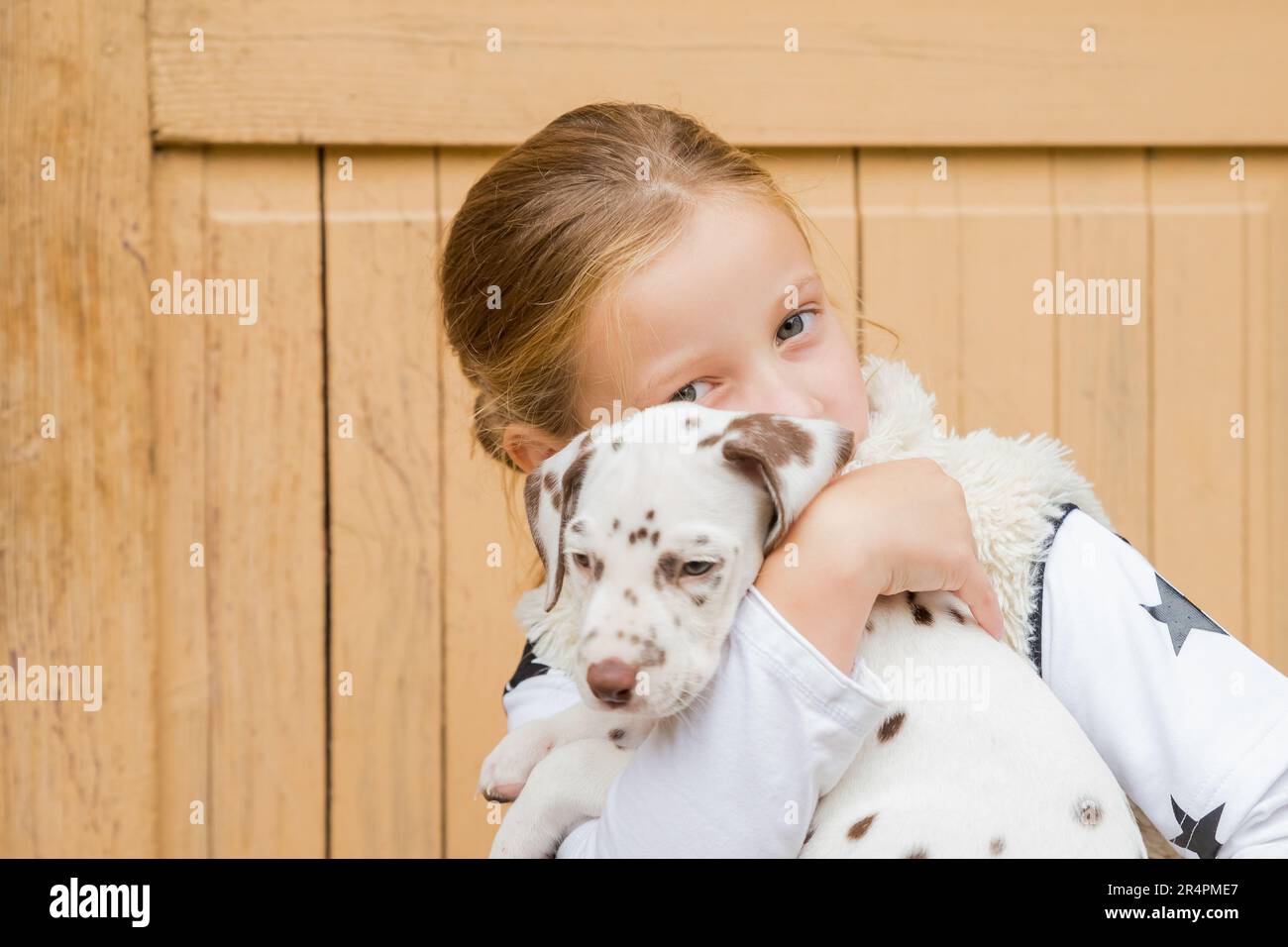 Kids play with cute little puppy of dalmatian. Children and baby dogs ...