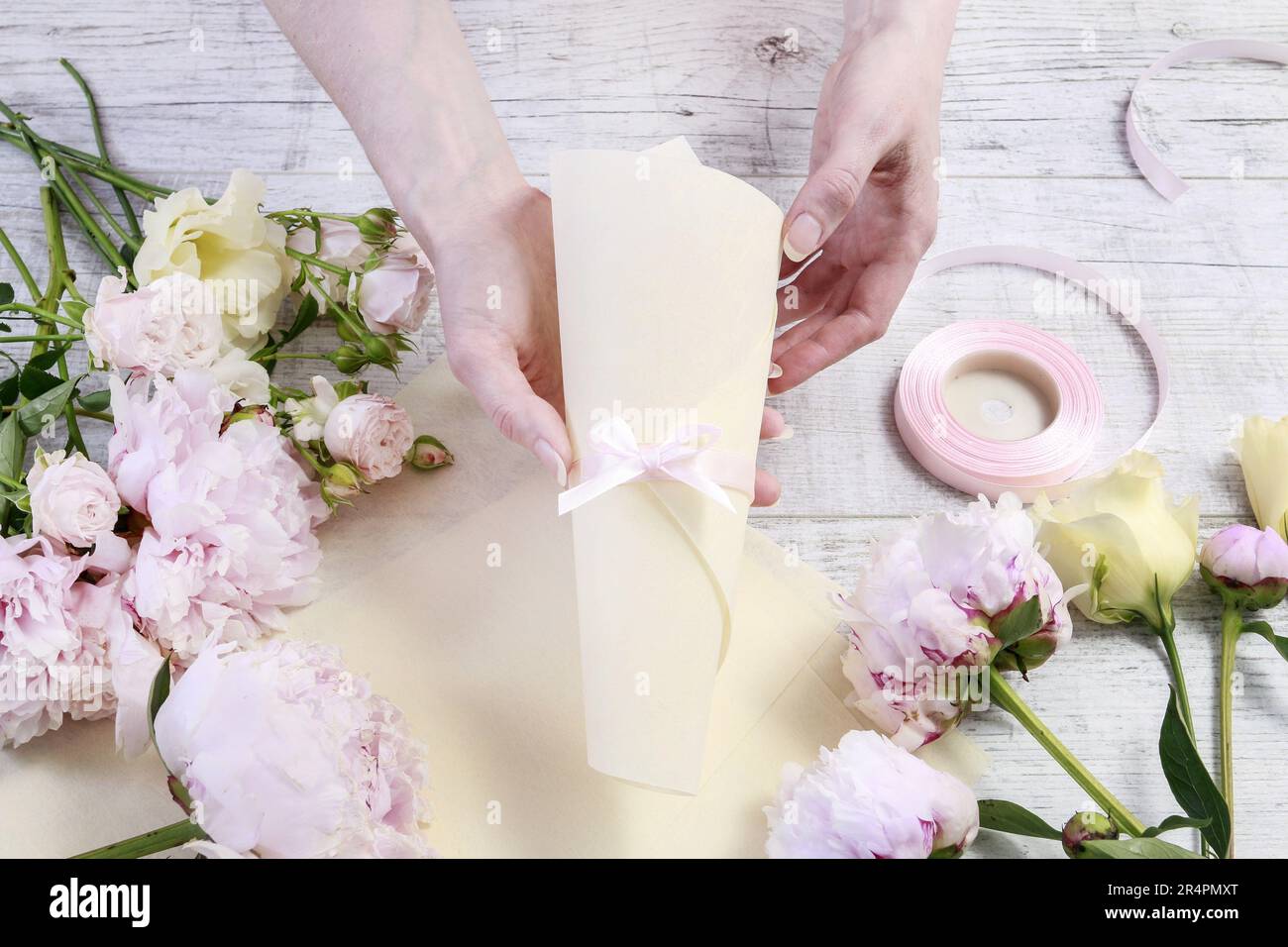 Florist at work: woman shows who to arrange flowers inside a paper ...