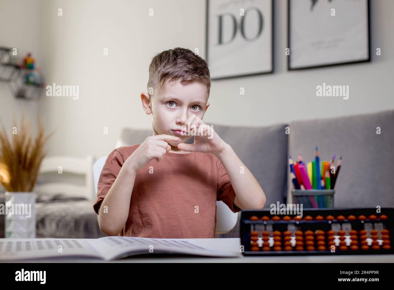 Little preschooler counting large numbers on his fingers using mental ...