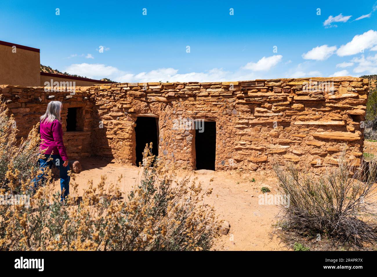 Lone female tourist; exterior view; replica of ancient Puebloan stone ...