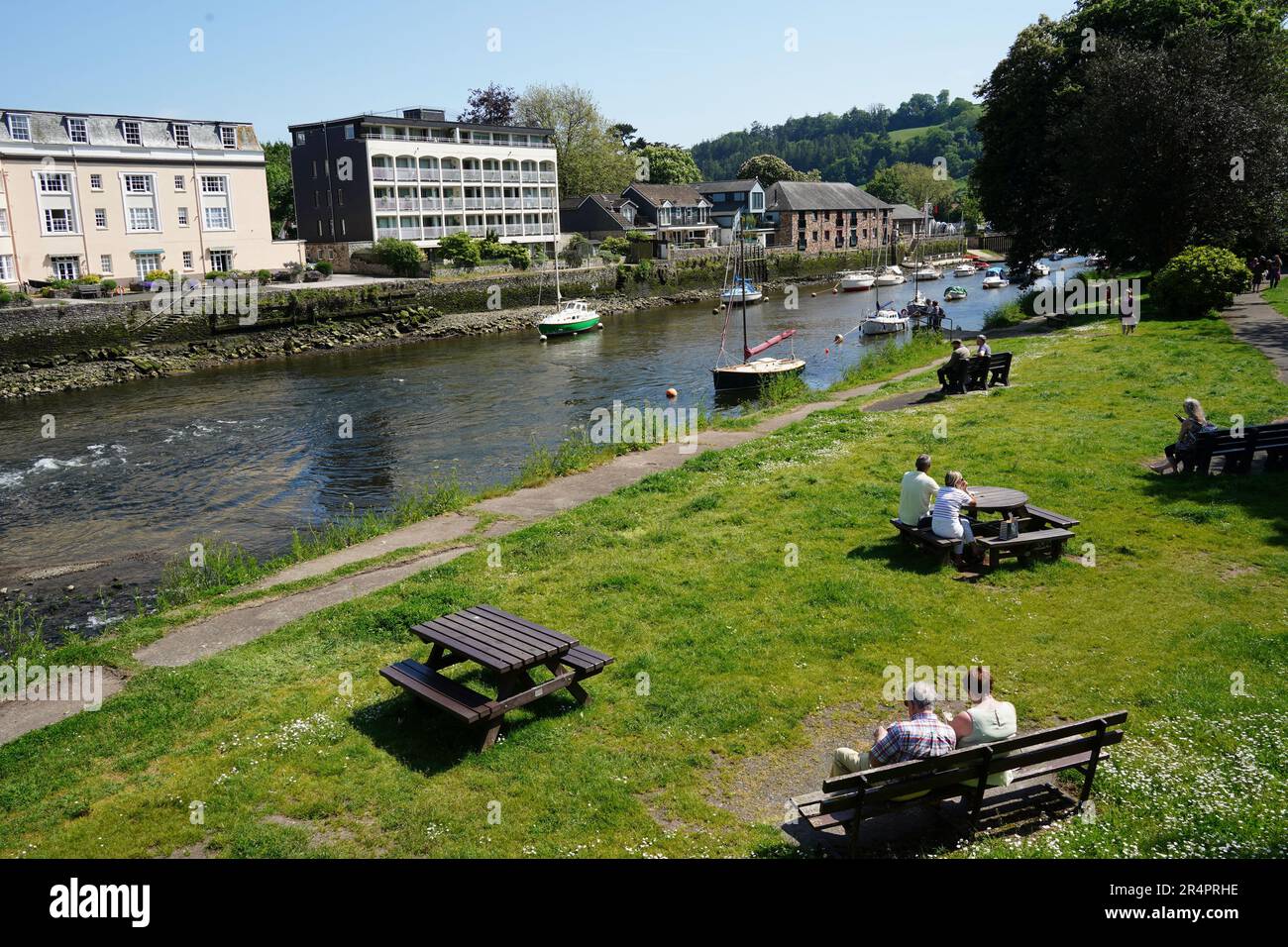 Totnes, UK - Mary 2023: Visitors in Totnes town, with river Dart in the ...