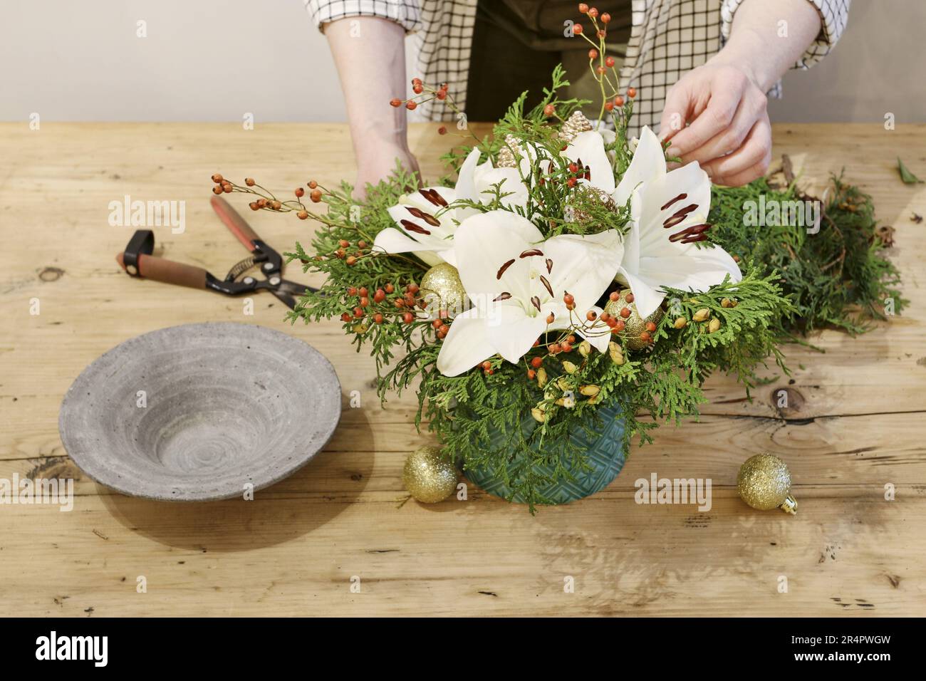 Christmas floral arrangement with white lilies, thuja twigs and golden ...