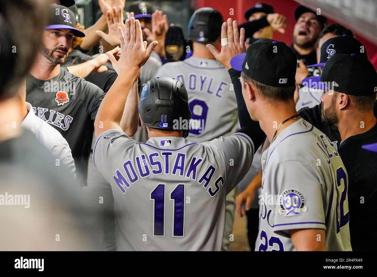 Colorado Rockies' Mike Mustakas (11) and Brenton Doyle (9) are greeted ...