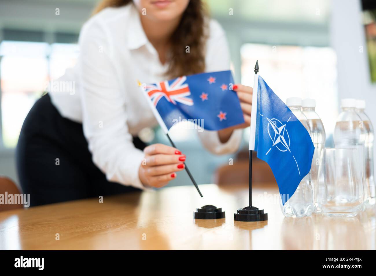 Female secretary places flags of the NATO (OTAN) and Australia on the ...