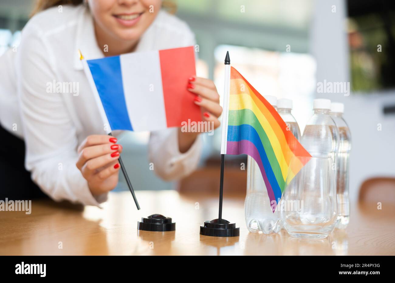 Unrecognizable girl sets midget flags of LGBT and France before ...