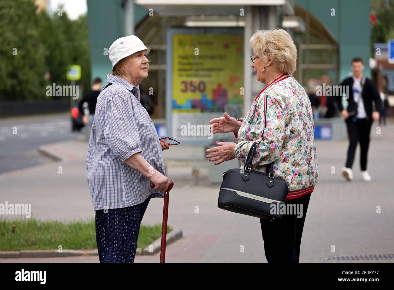 Two old woman talking on a street. Life of retirees in city Stock Photo ...