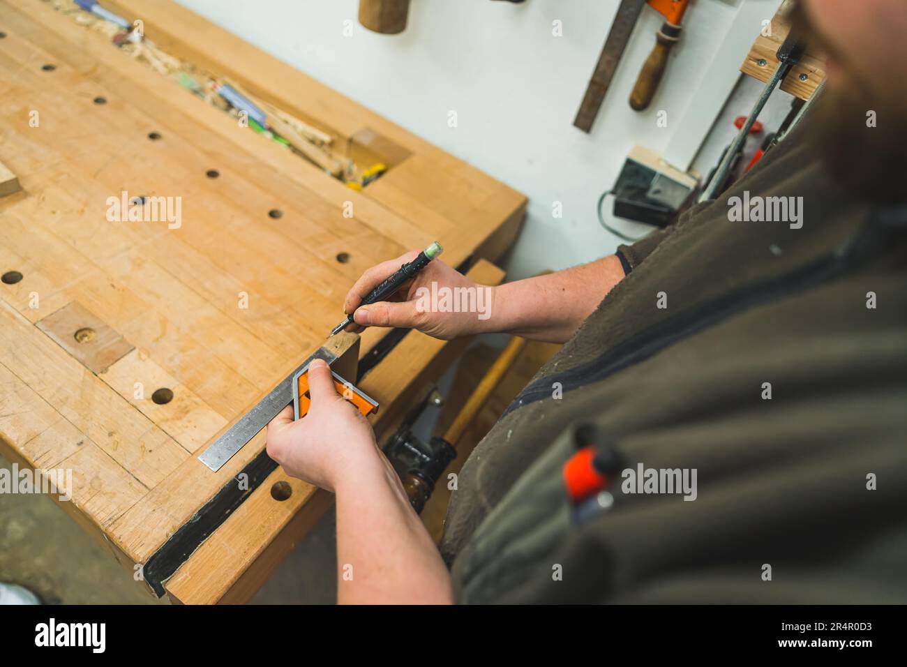 Hands of carpenter carefully drawing line using marker and ruler on ...