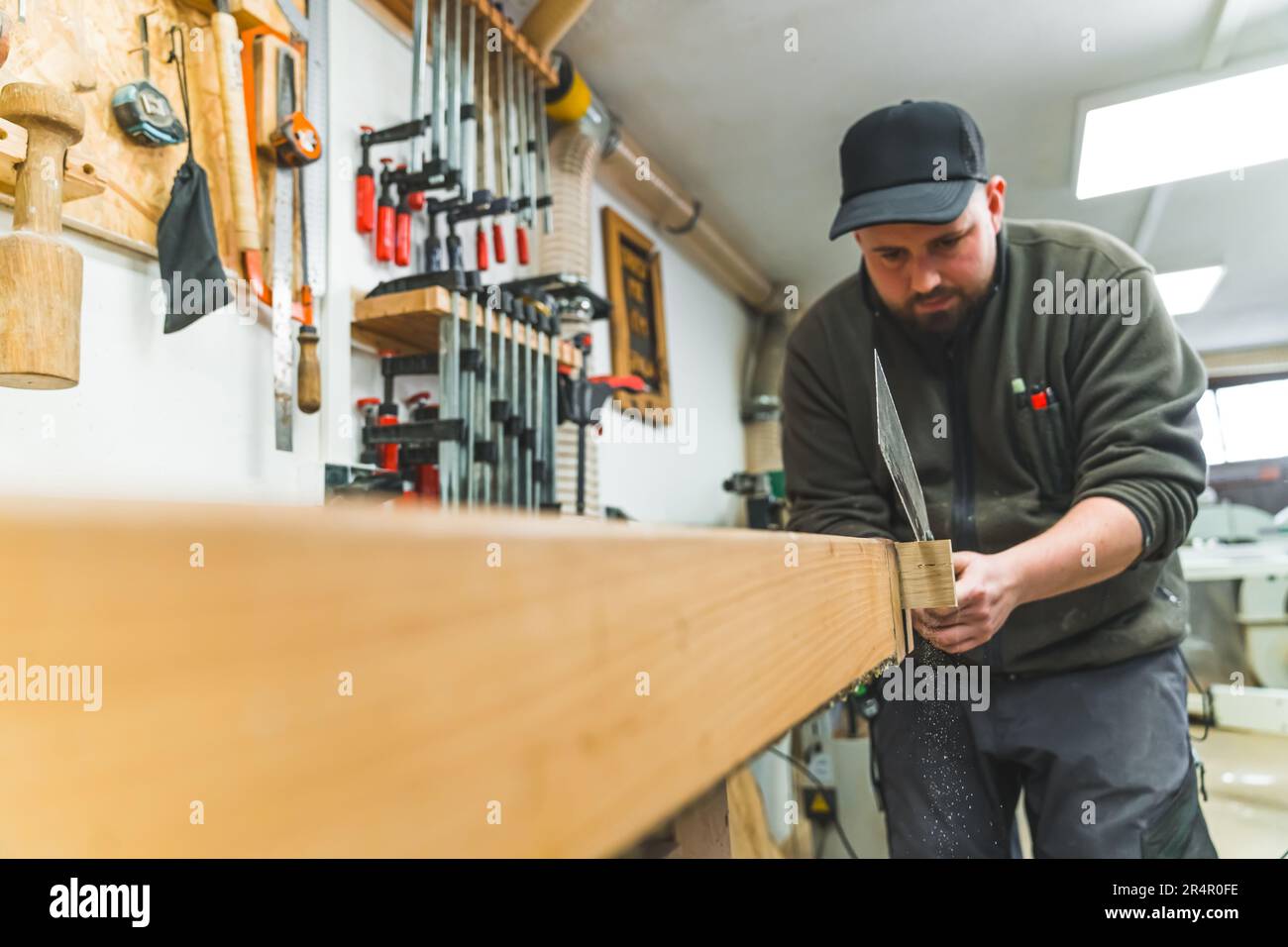 Caucasian carpenter using a tenon saw and cutting wood in his workshop ...