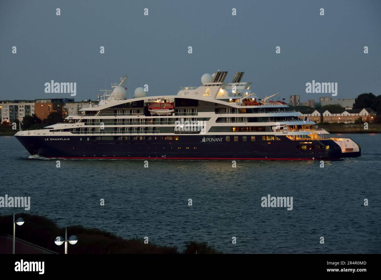 Ponant Cruises ship Le Champlain heading down the River Thames at dusk ...