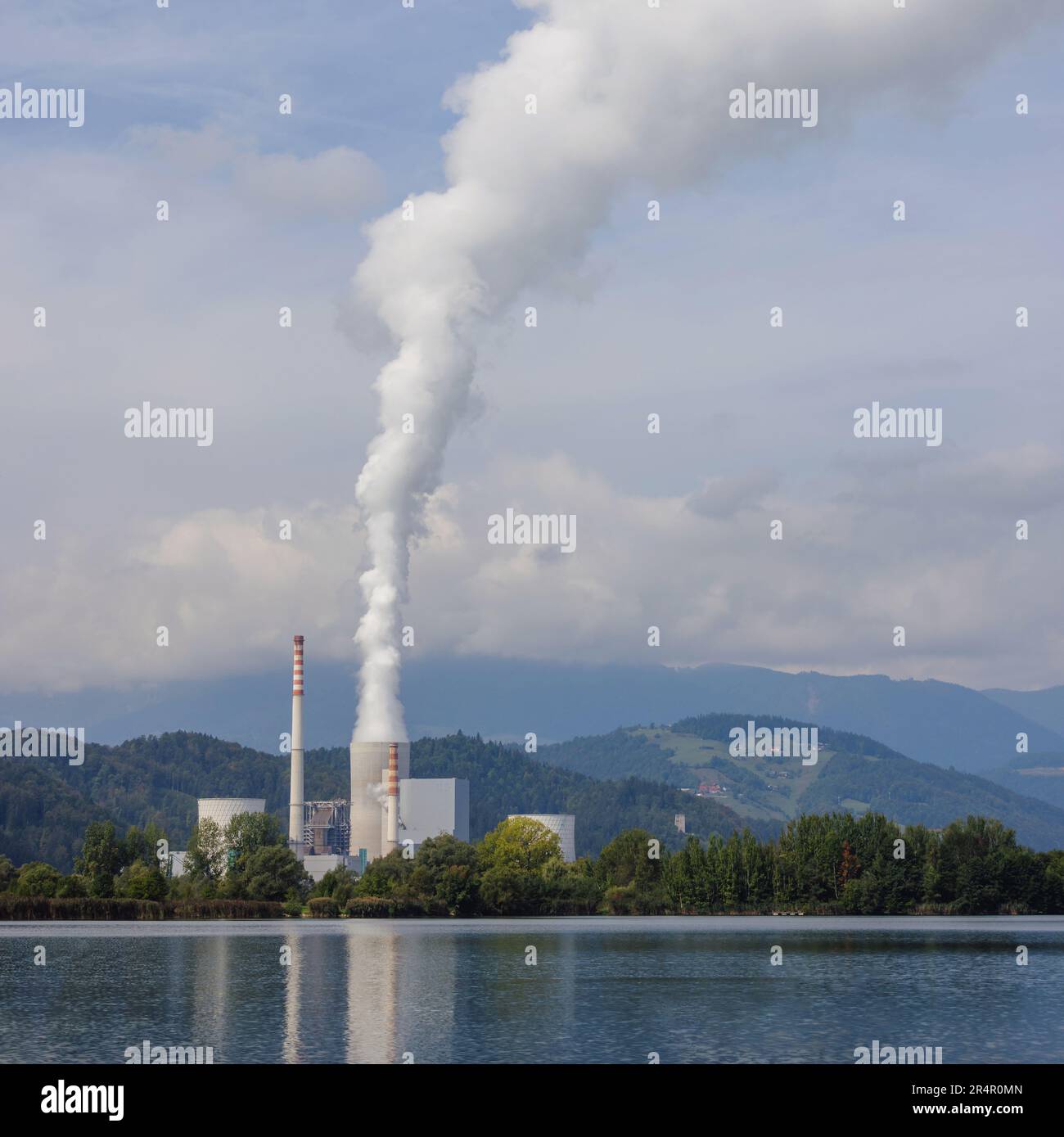 Smoking chimney at thermal power plant near lake and green nature Stock ...