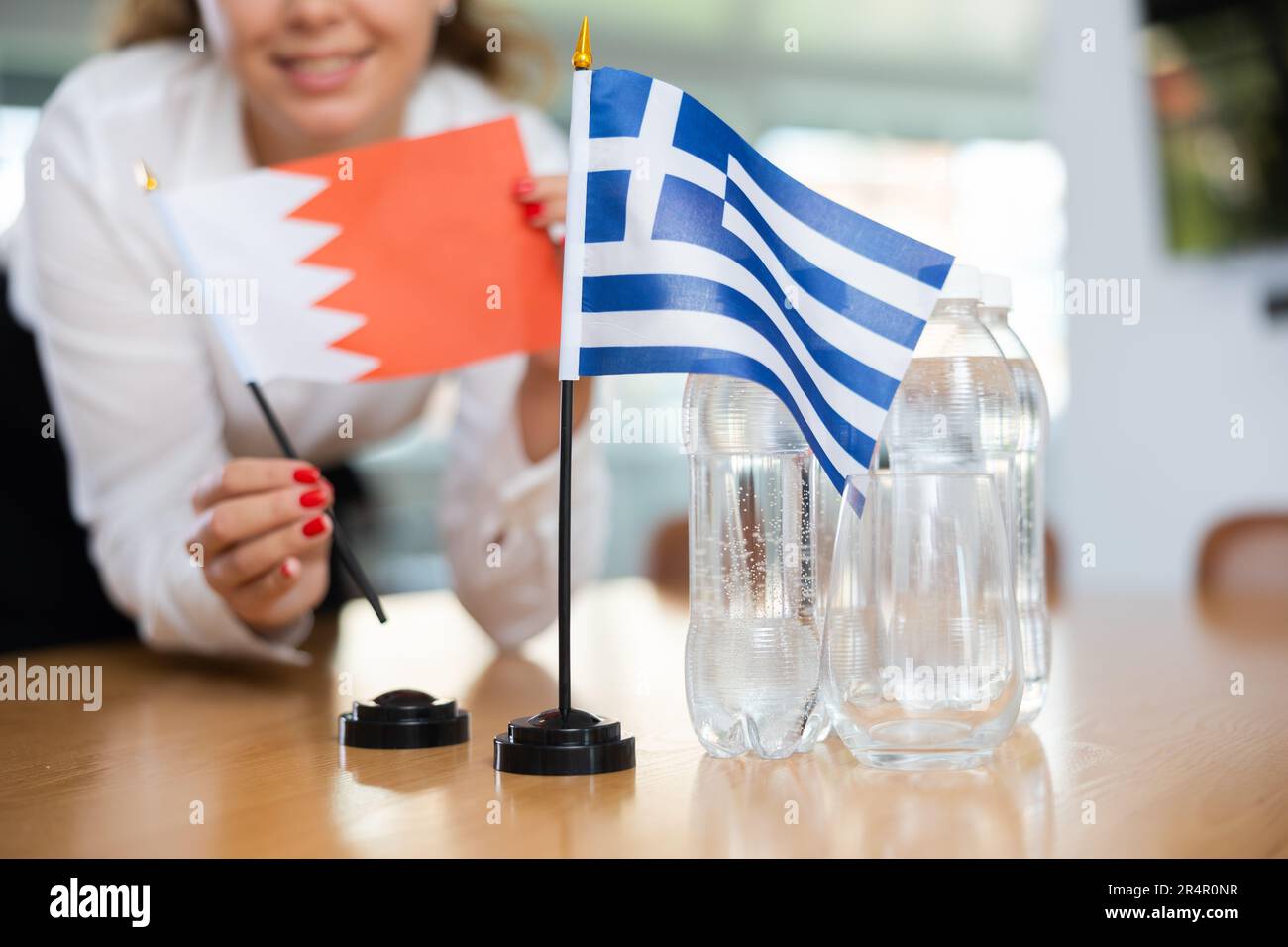 Unrecognizable girl sets midget flags of Greece and Bahrein before ...