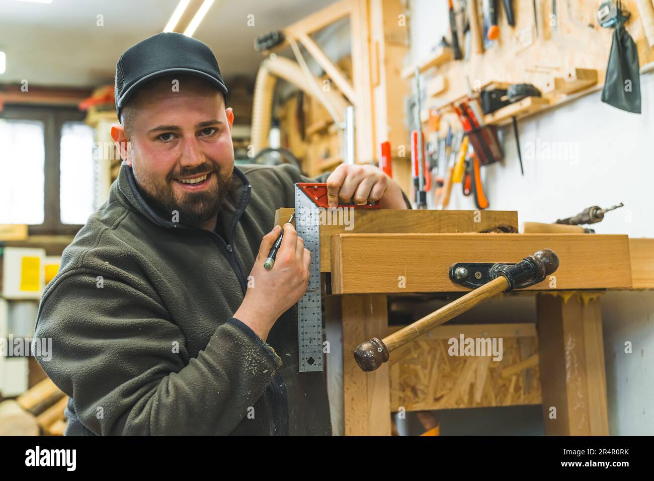 young craftsman using a set square marking a point and showing thumb up ...