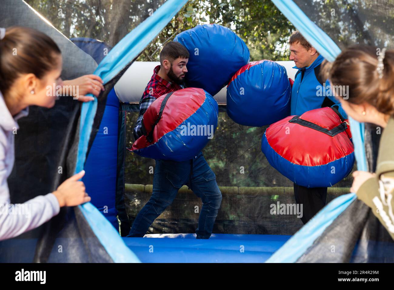 Male friends fighting at amusement playground Stock Photo - Alamy
