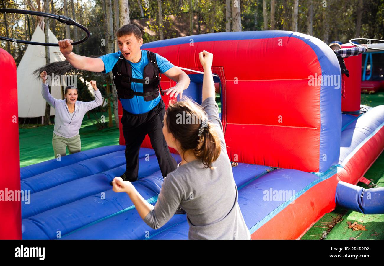 Friends having fun passing obstacle course Stock Photo - Alamy