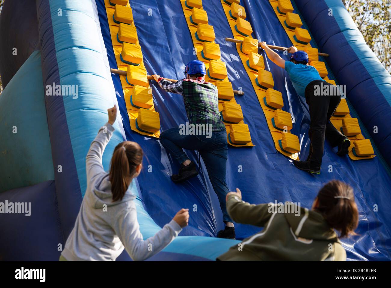 Friends having fun passing obstacle course Stock Photo - Alamy