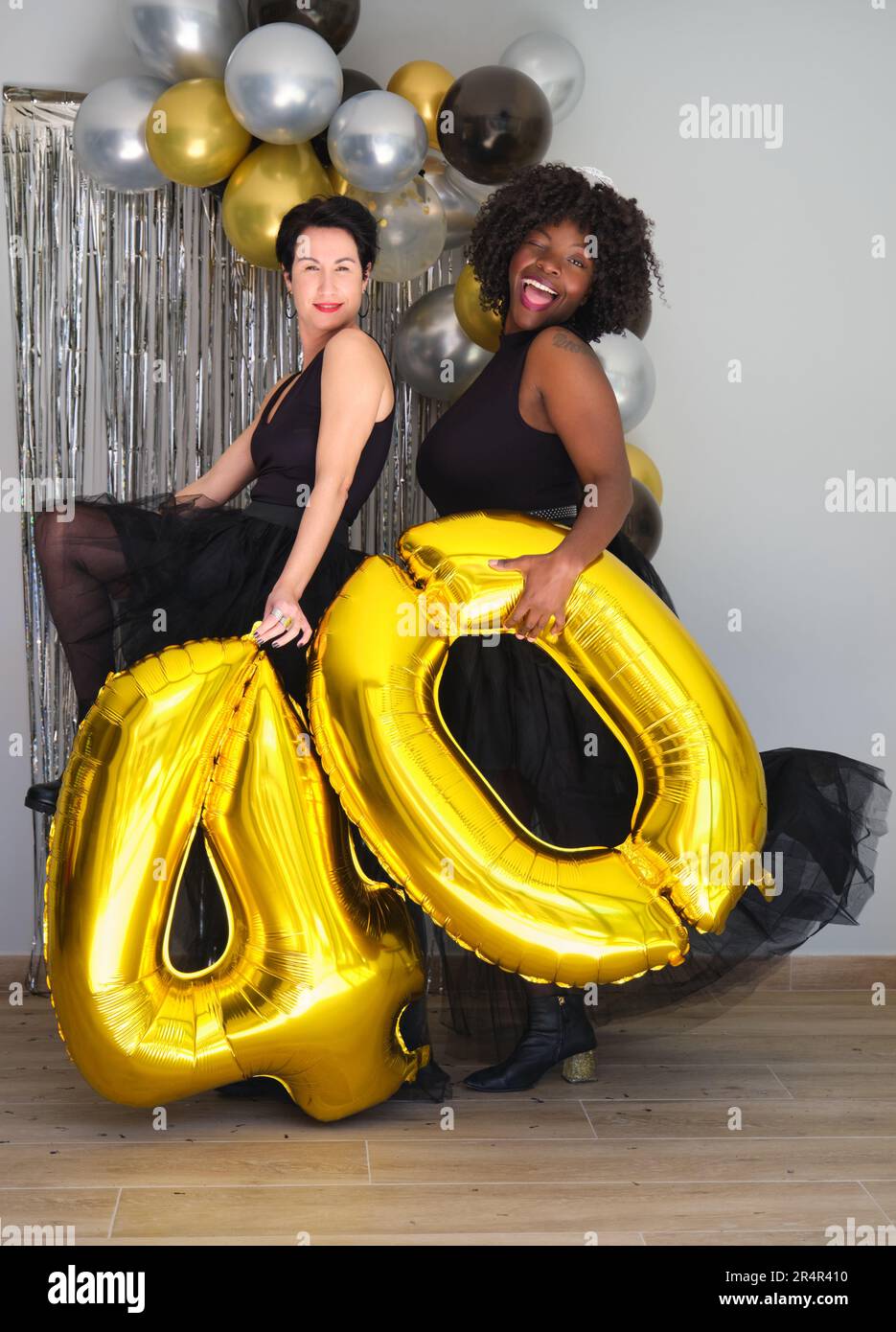 Two happy multiracial women in a 40 birthday party with 40 birthday ...