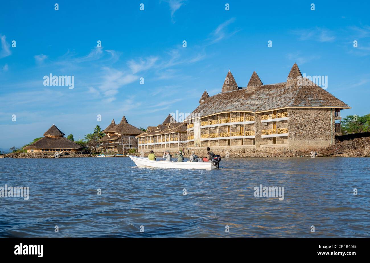 A small boat carrying tourists to a luxury wildness lodge on the shore ...