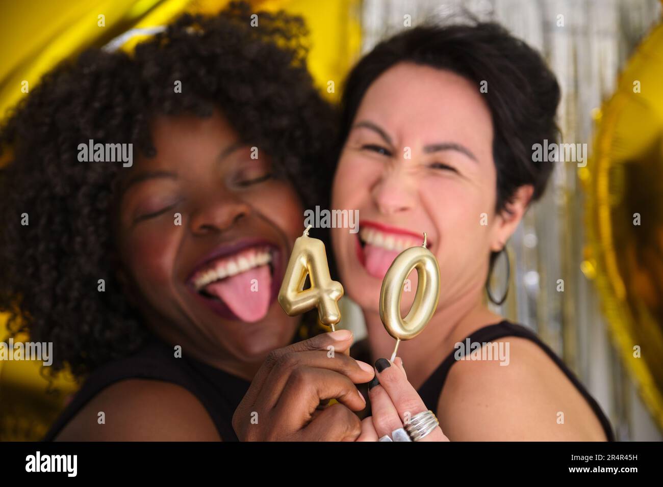 Two multiracial happy women in a 40 birthday party with 40 birthday ...