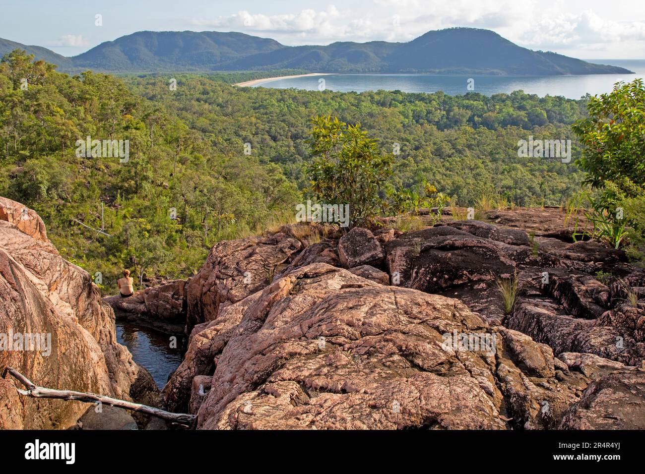 Woman looking over Zoe Bay from the top of Zoe Falls, Hinchinbrook ...