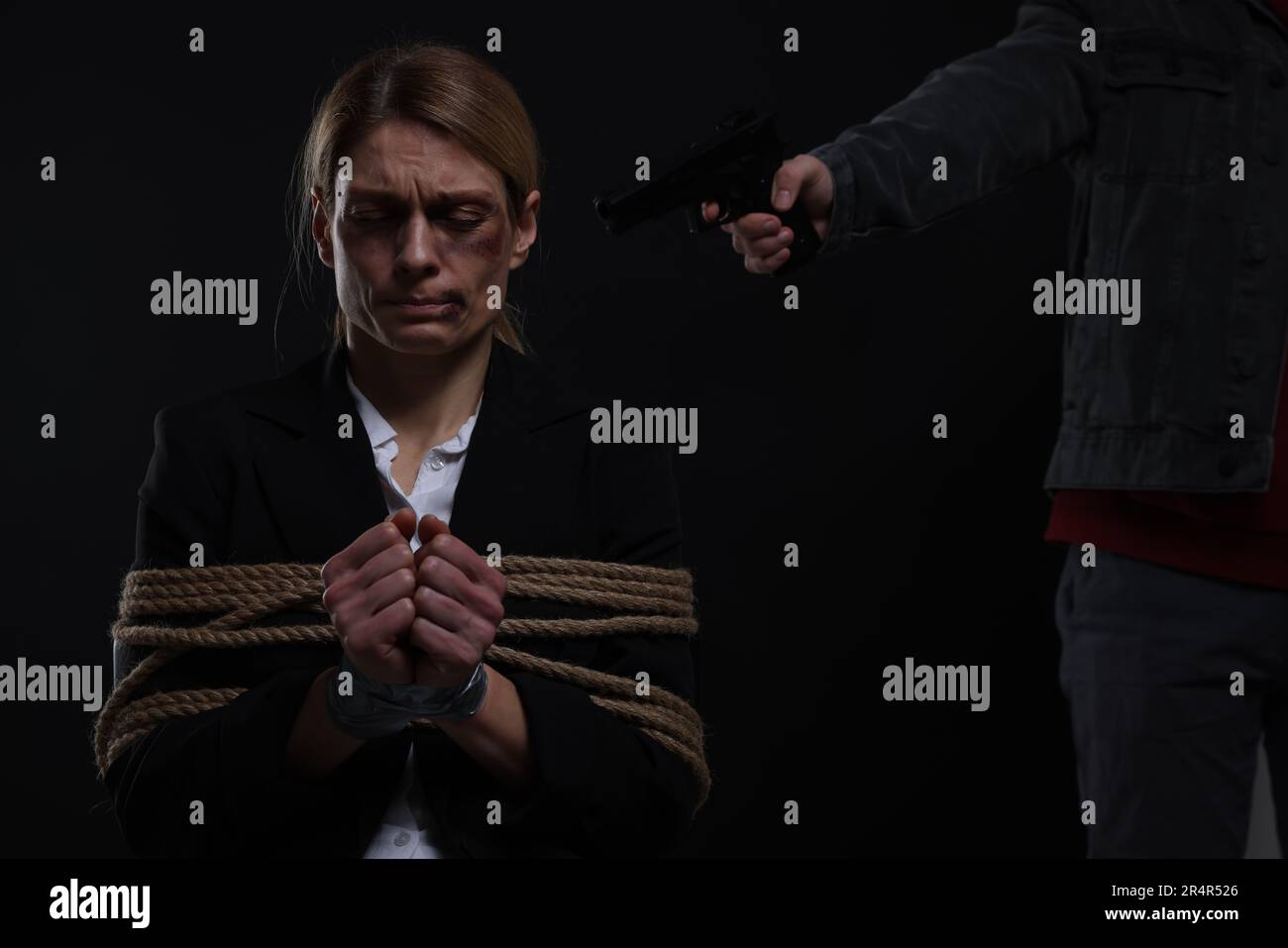 Kidnapper pointing gun at tied up woman taken as hostage on dark ...