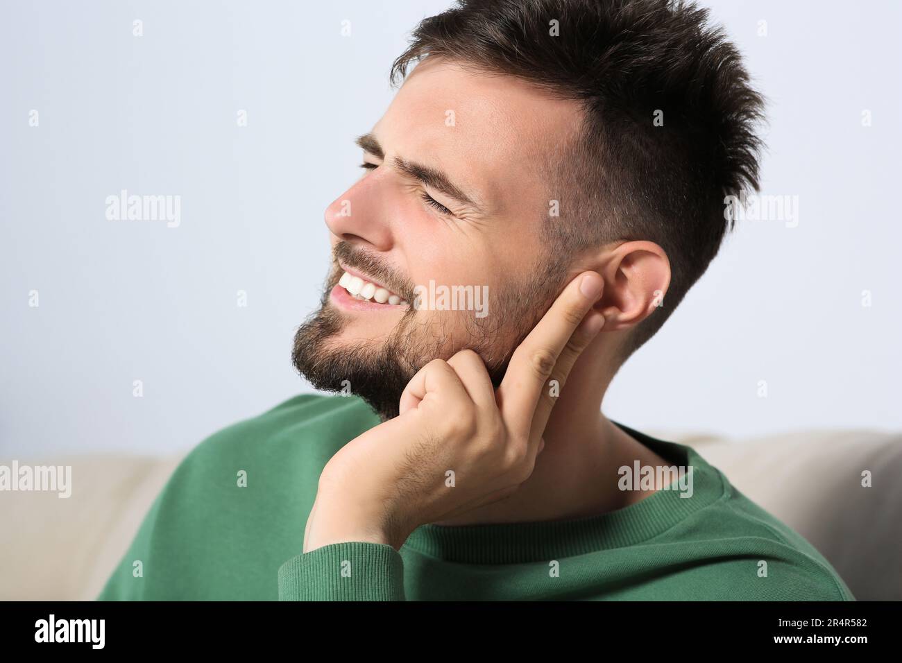 Young man suffering ear pain hi-res stock photography and images - Alamy