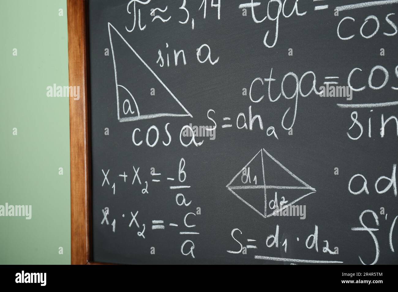 Chalkboard with many different math formulas on green wall, closeup ...