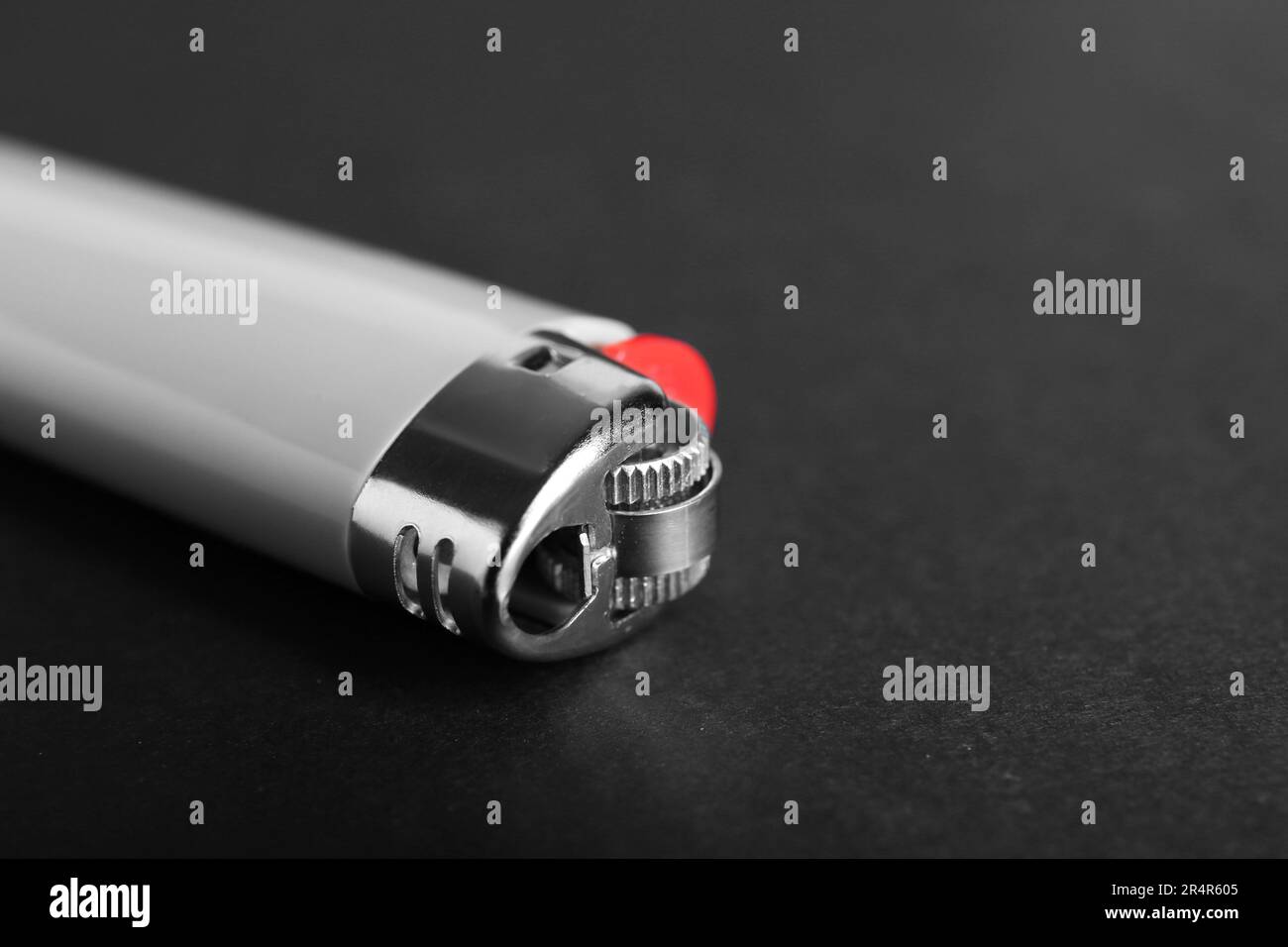 Stylish small pocket lighter on black background, closeup. Space for ...