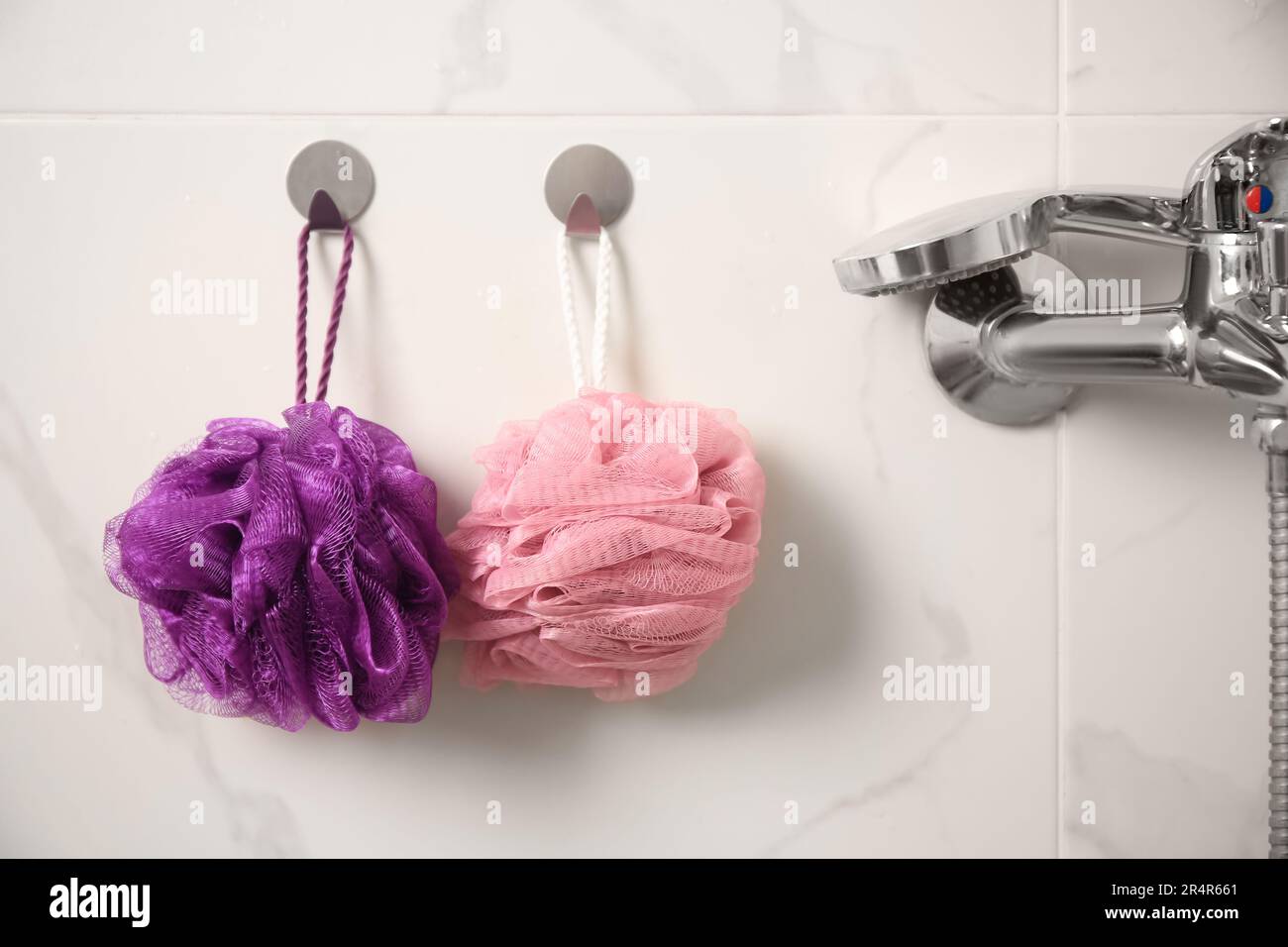 Shower puffs hanging near faucet in bathroom Stock Photo - Alamy