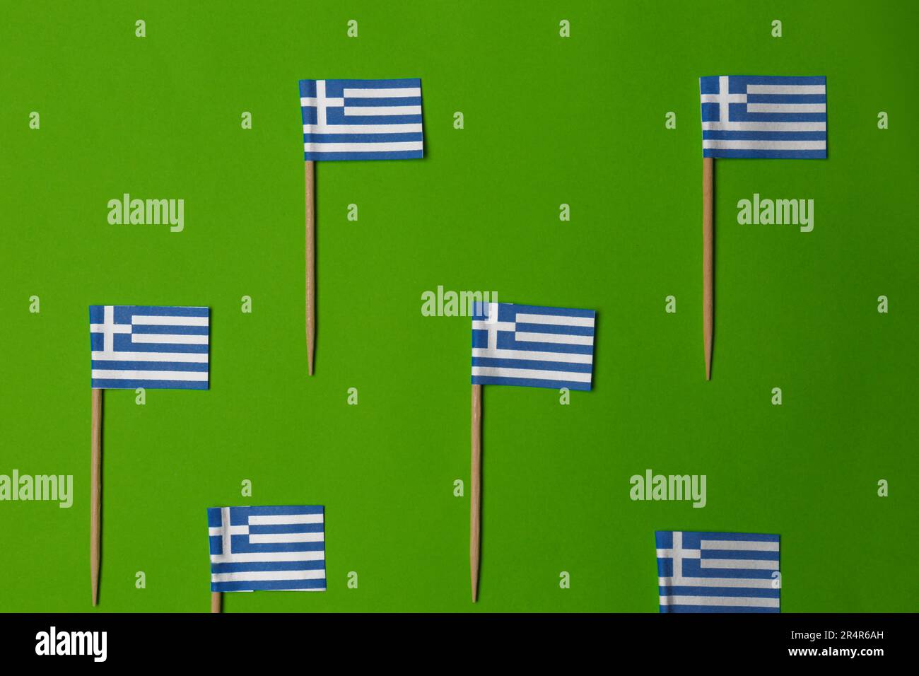 Small paper flags of Greece on green background, flat lay Stock Photo ...