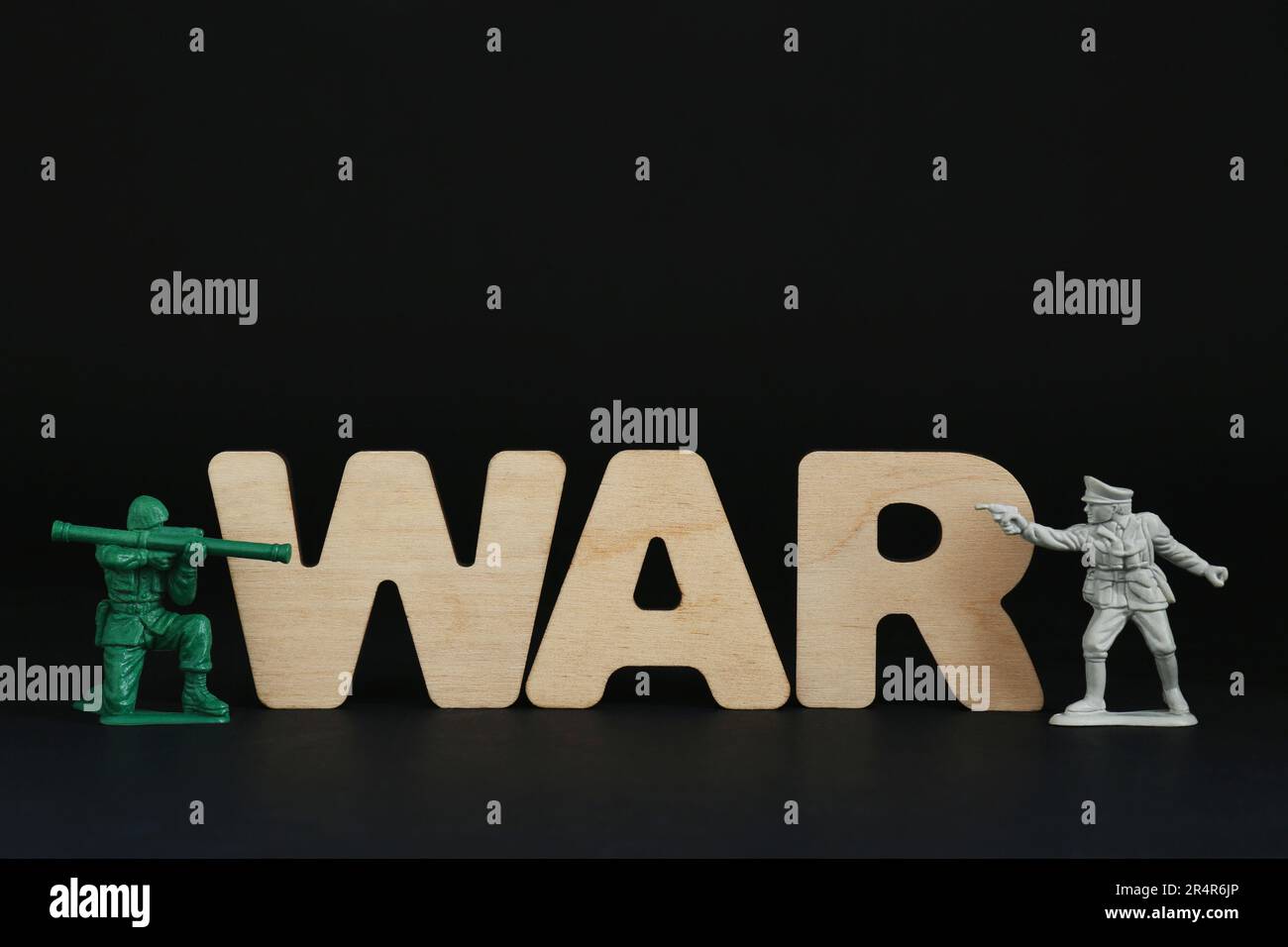Word War made of wooden letters and toy soldiers on black background ...