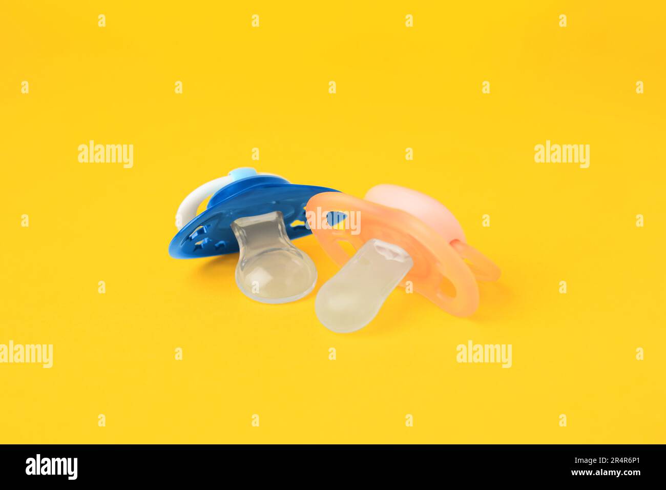 Colorful baby pacifiers on bright orange background Stock Photo - Alamy