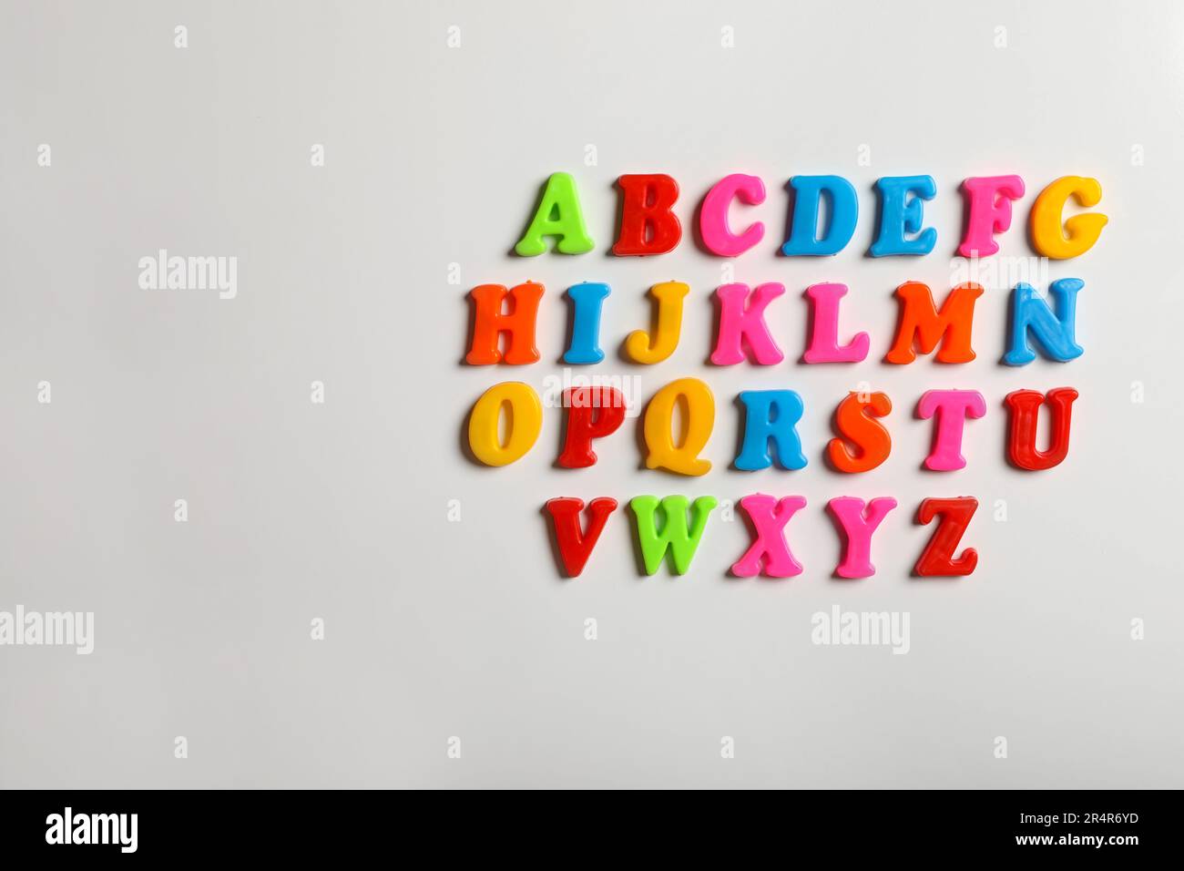 Colorful magnetic letters on white background, flat lay. Alphabetical ...
