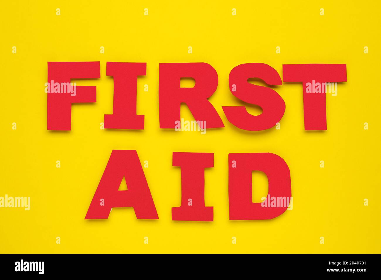 Words First Aid made of red letters on yellow background, flat lay ...