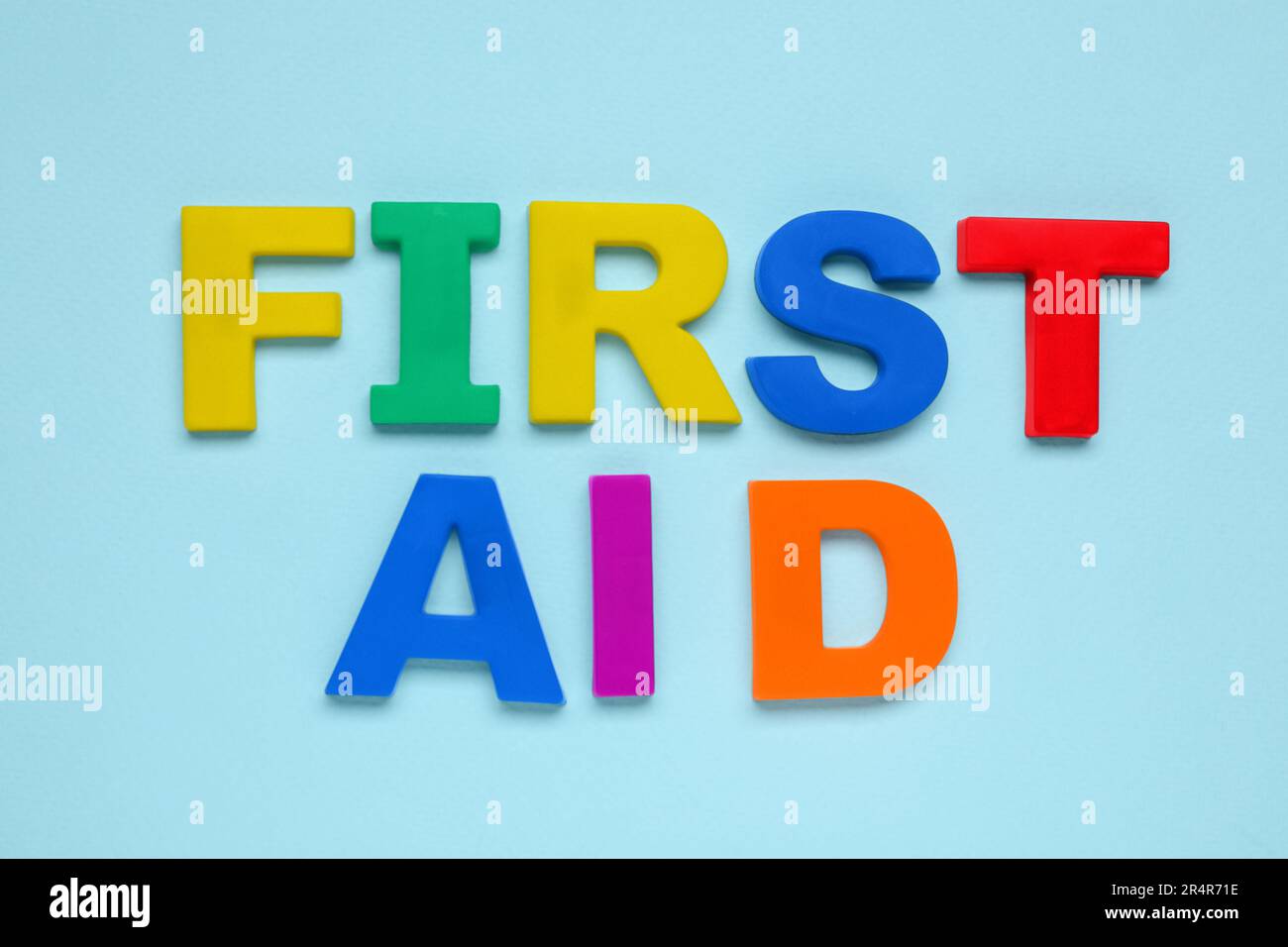 Words First Aid made of colorful letters on light blue background, flat ...