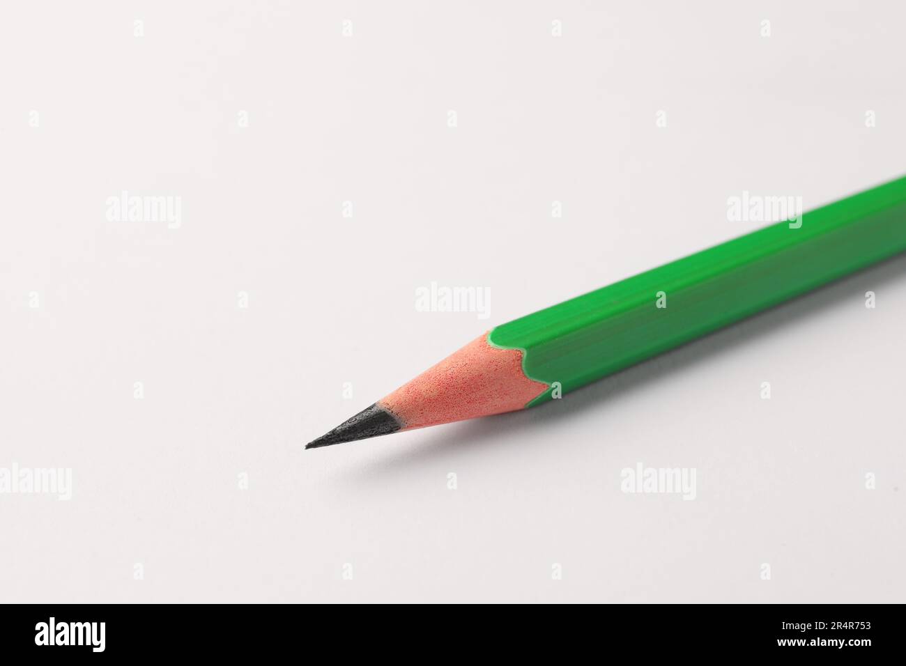 Sharp graphite pencil on white background, closeup. Space for text ...