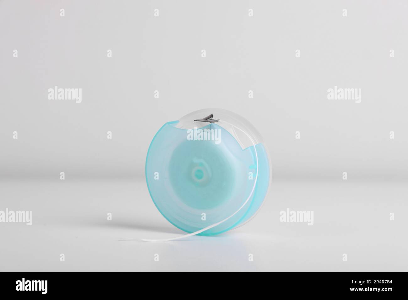 Container with dental floss on white background Stock Photo - Alamy