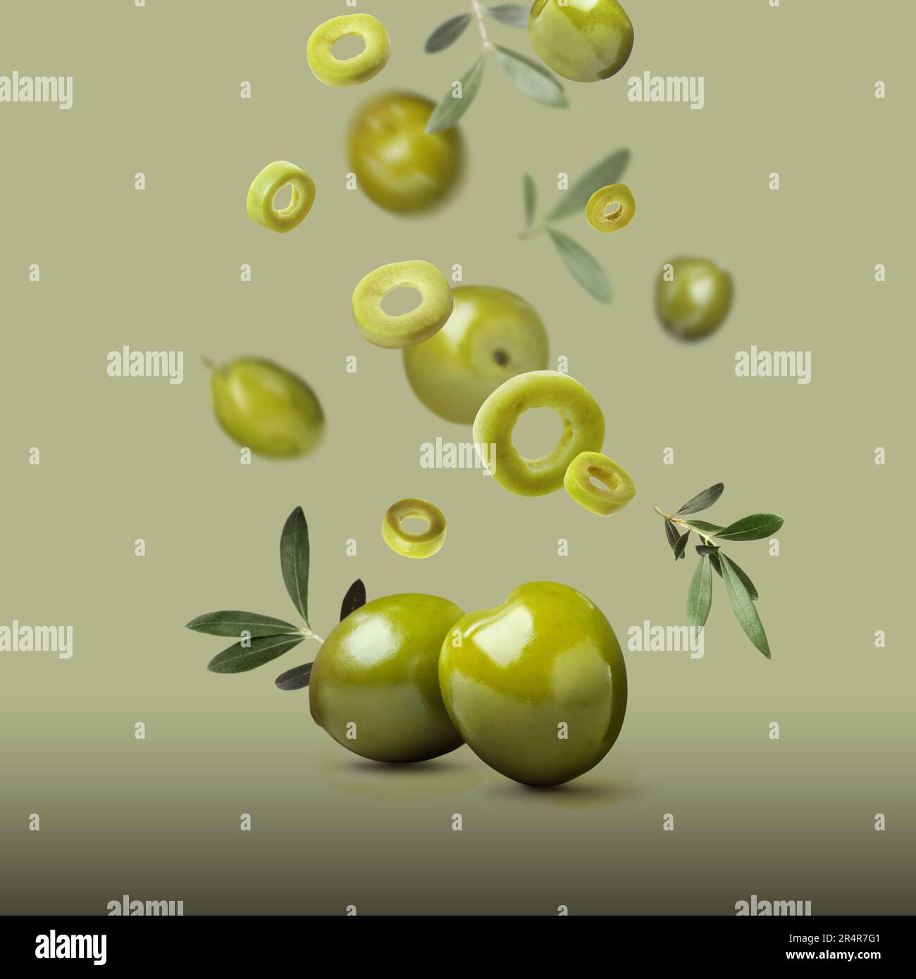 Fresh olives and leaves falling on pale olive background Stock Photo ...