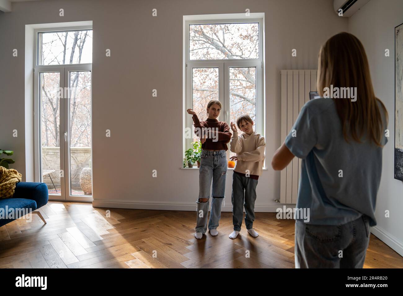 Mother holding smartphone helping kids to record funny dance video for ...