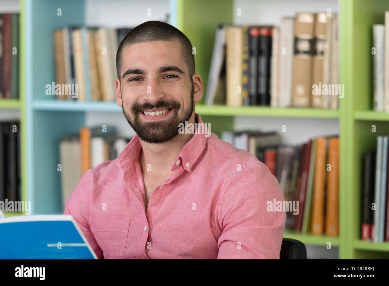 Handsome Male Student With Books Working in a High School Library Stock ...