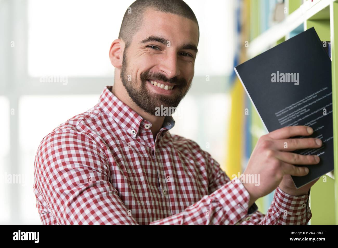 Handsome Male Student With Books Working in a High School Library Stock ...