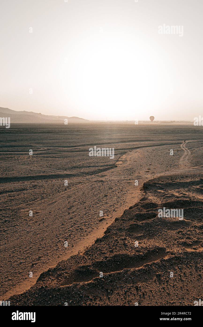 Vast open mars like field with brown sand and rocks and mountains and ...